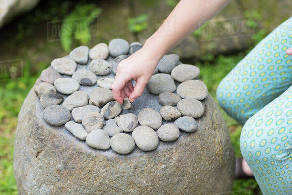 Caucasian girl arranging stones on boulder - Royalty-free Stock Photo ...