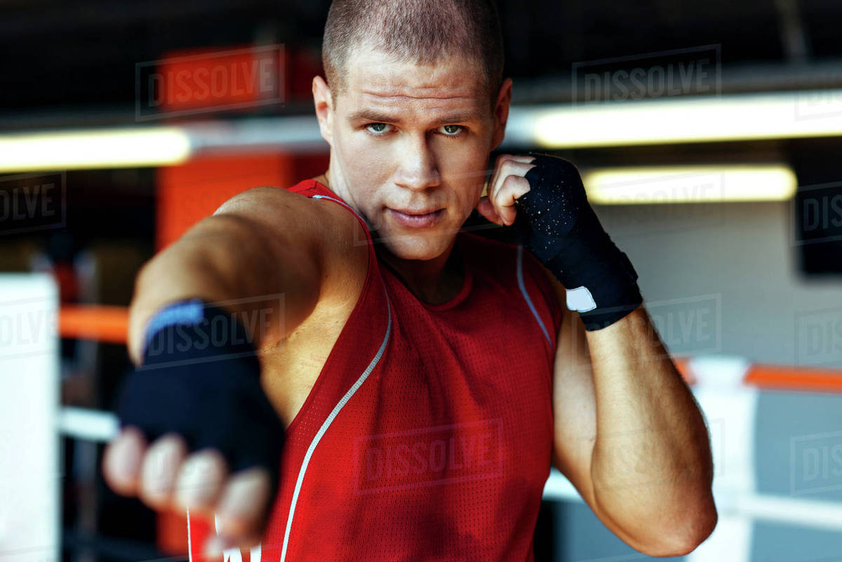 Portrait of Caucasian boxer punching - Royalty-free Stock Photo | Dissolve