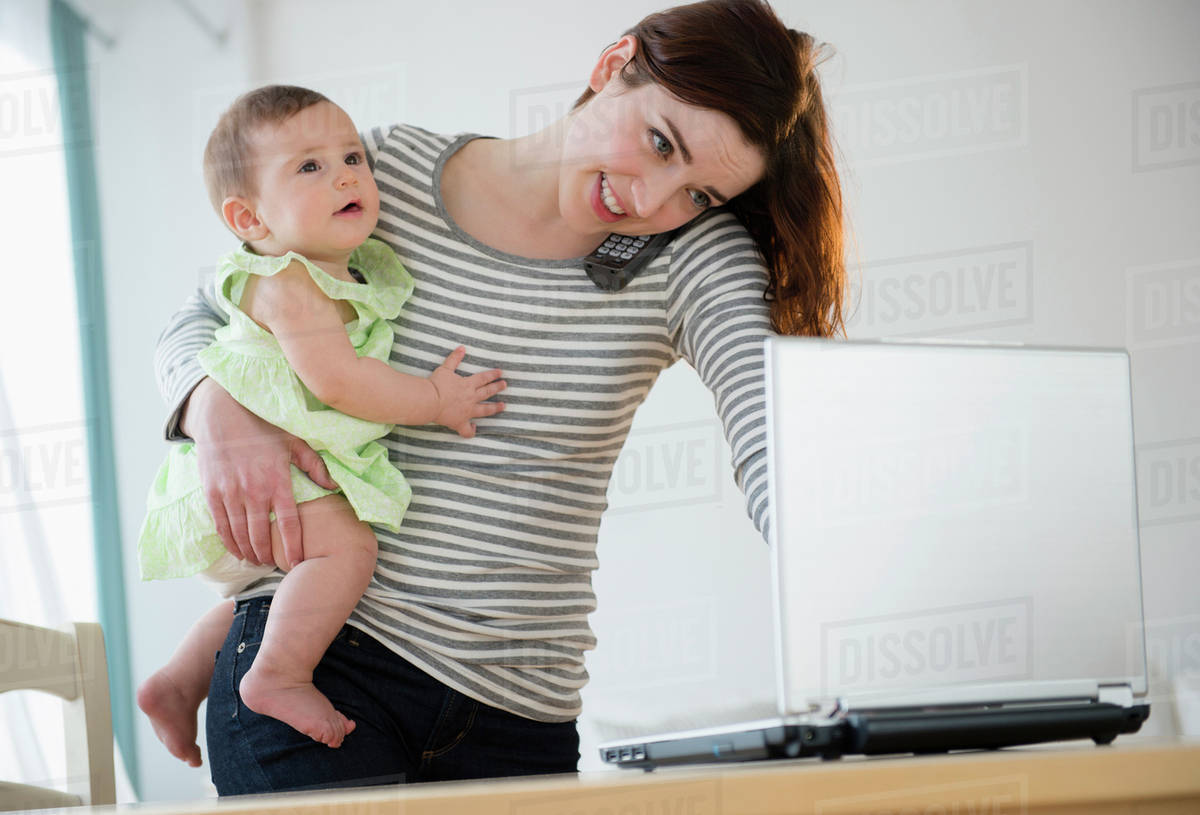 Mother multitasking with baby - Royalty-free Stock Photo | Dissolve