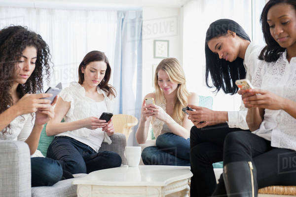 Women using cell phones in living room - Royalty-free Stock Photo ...