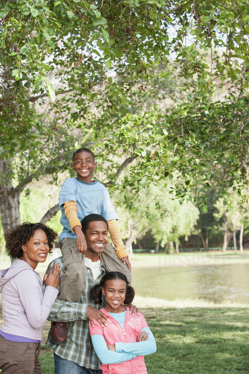 Family smiling together in park - Royalty-free Stock Photo | Dissolve