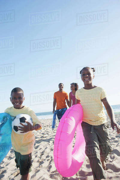 Children carrying inner tubes on beach - Royalty-free Stock Photo ...
