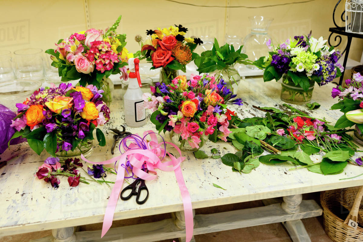 Flower arrangements on work table in florist - Stock Photo - Dissolve