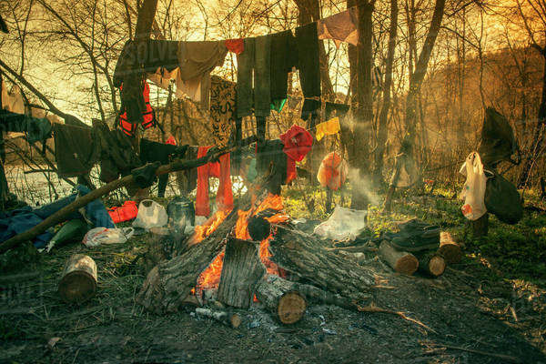 Clothes hanging over fire at campsite - Royalty-free Stock Photo | Dissolve
