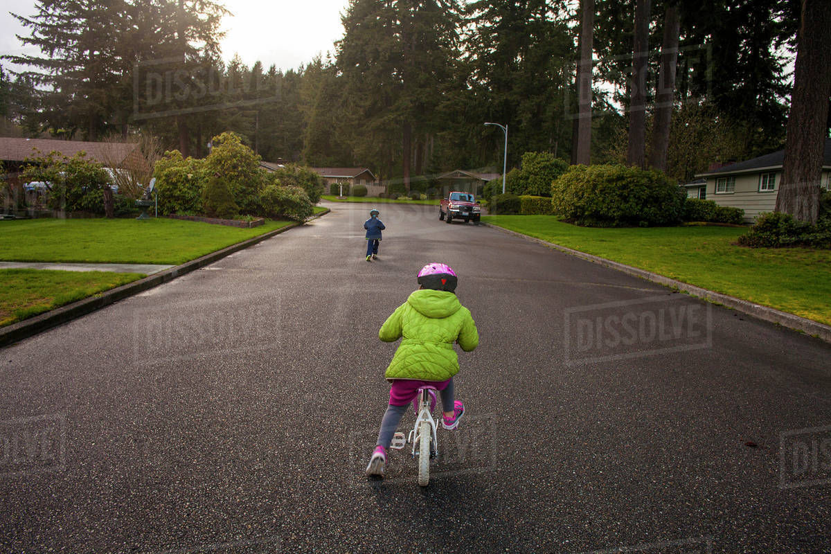 Caucasian children riding bicycles on suburban street - Royalty-free ...