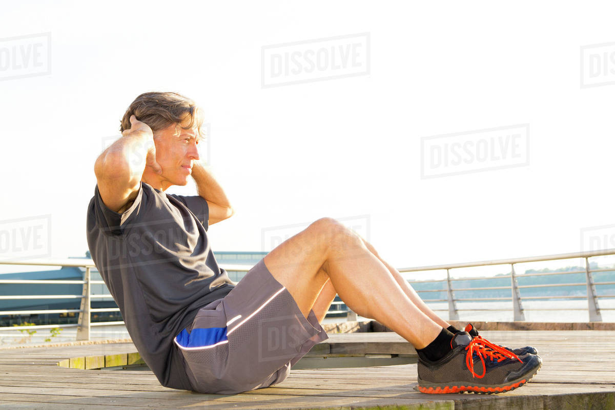 Caucasian man stretching in waterfront park - Royalty-free Stock Photo ...
