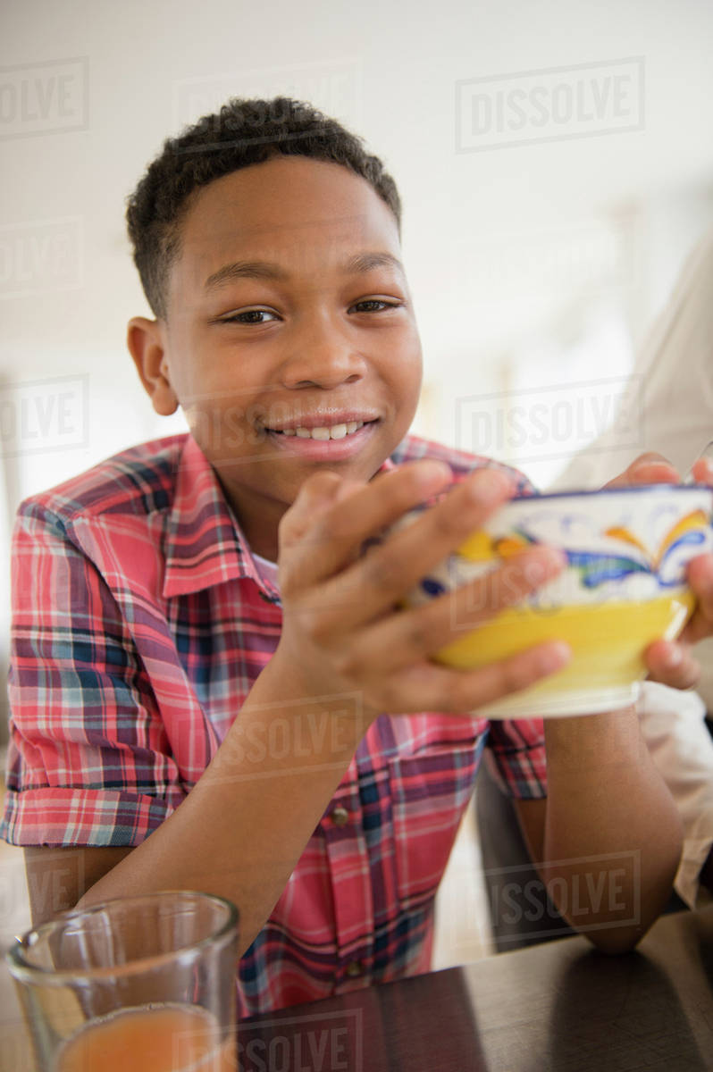 Black boy eating breakfast in kitchen - Stock Photo - Dissolve