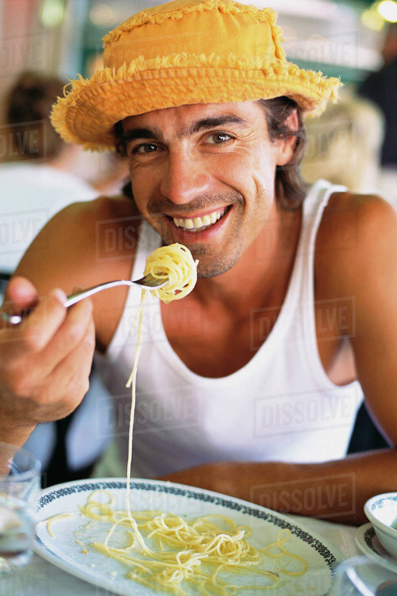 Man eating pasta at sidewalk cafe - Royalty-free Stock Photo | Dissolve