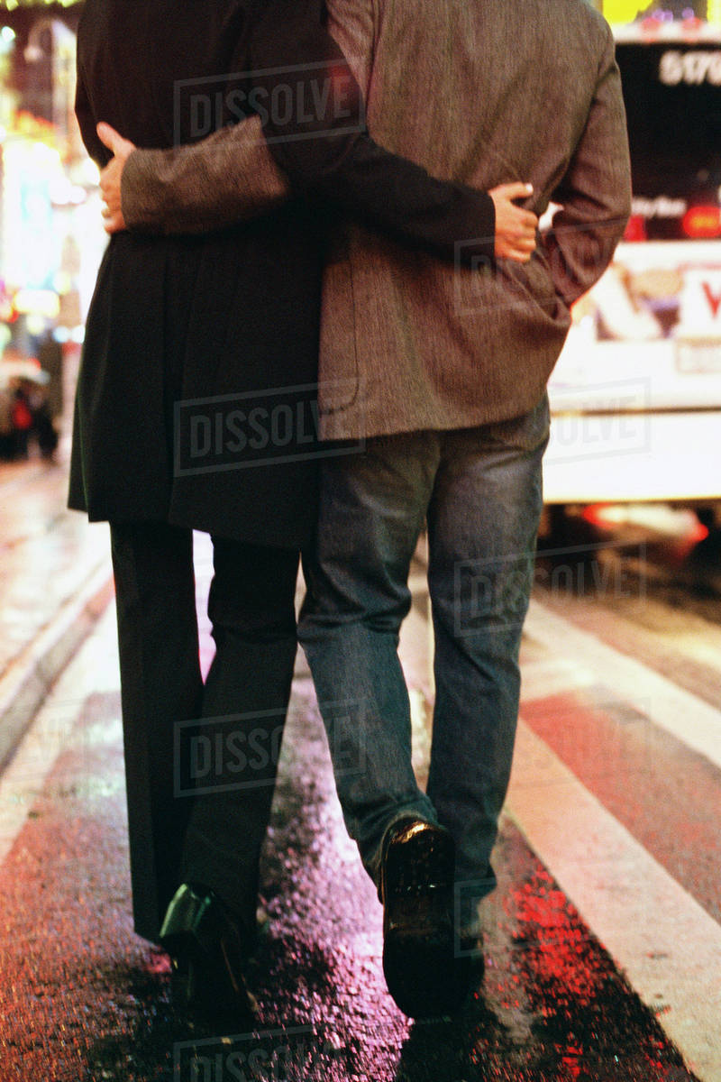 Couple walking on city street lit up at night - Royalty-free Stock ...