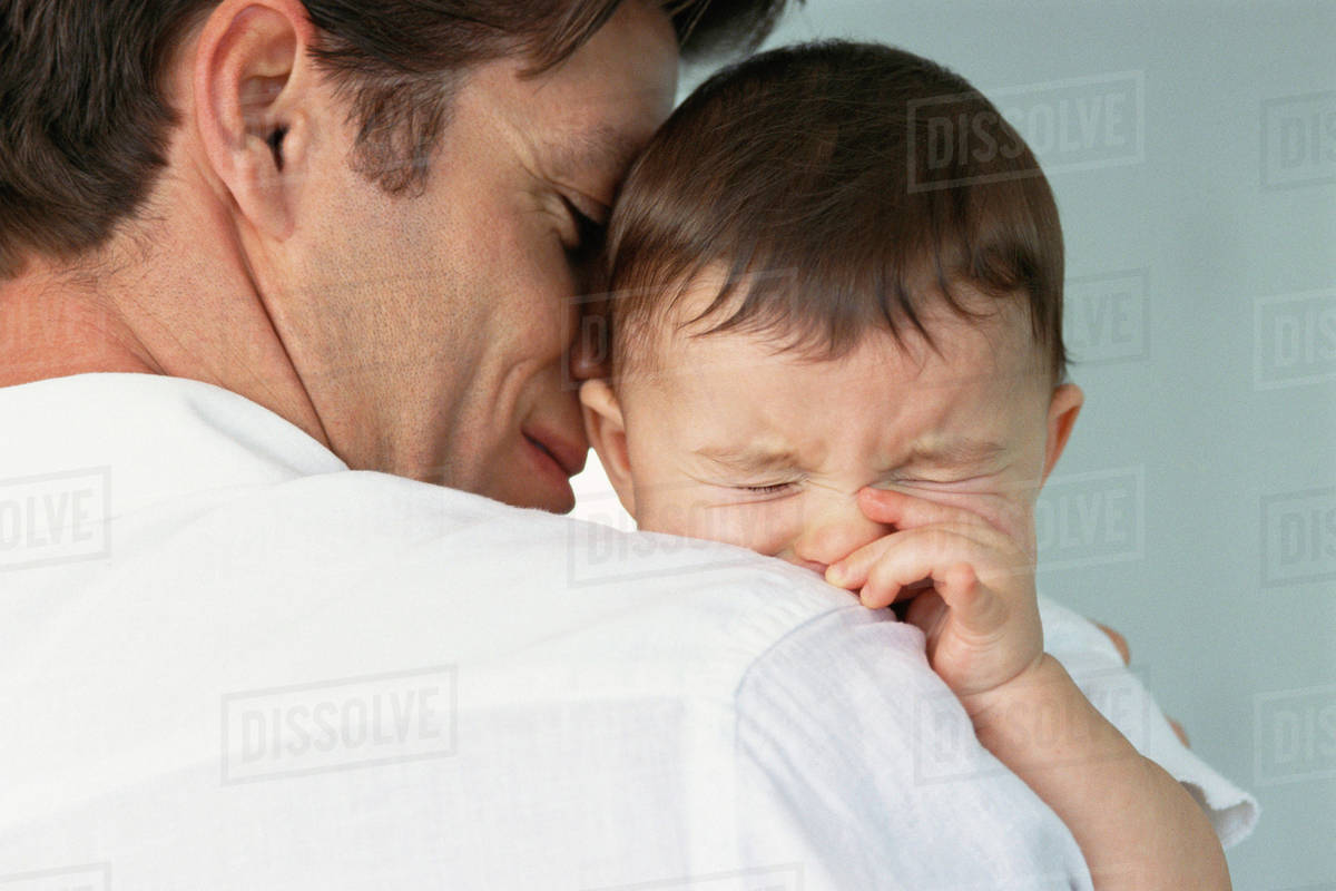 Father comforting crying baby - Royalty-free Stock Photo | Dissolve