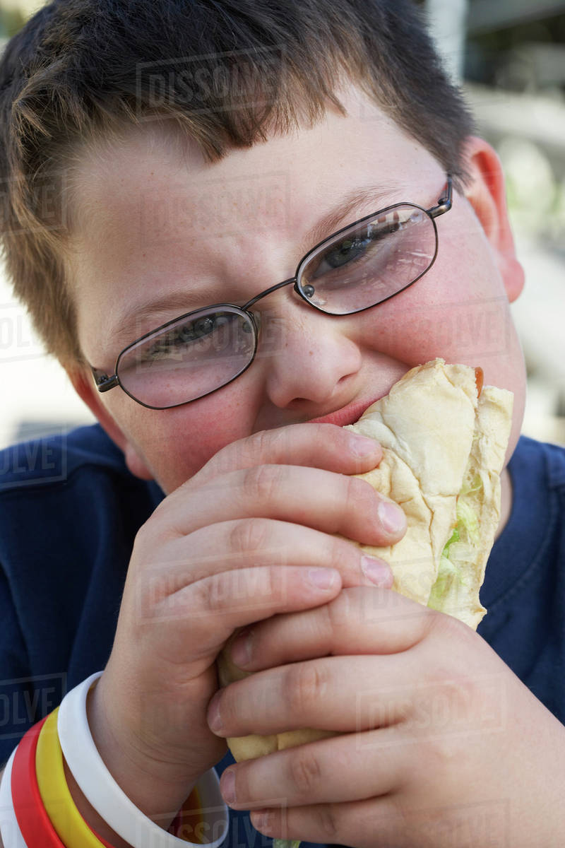 Boy eating sandwich outdoors - Royalty-free Stock Photo | Dissolve