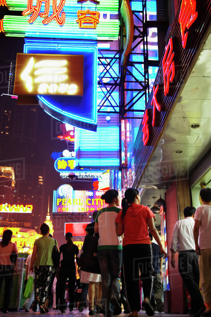 Couple on city street lit up at night, Shanghai, China - Royalty-free ...