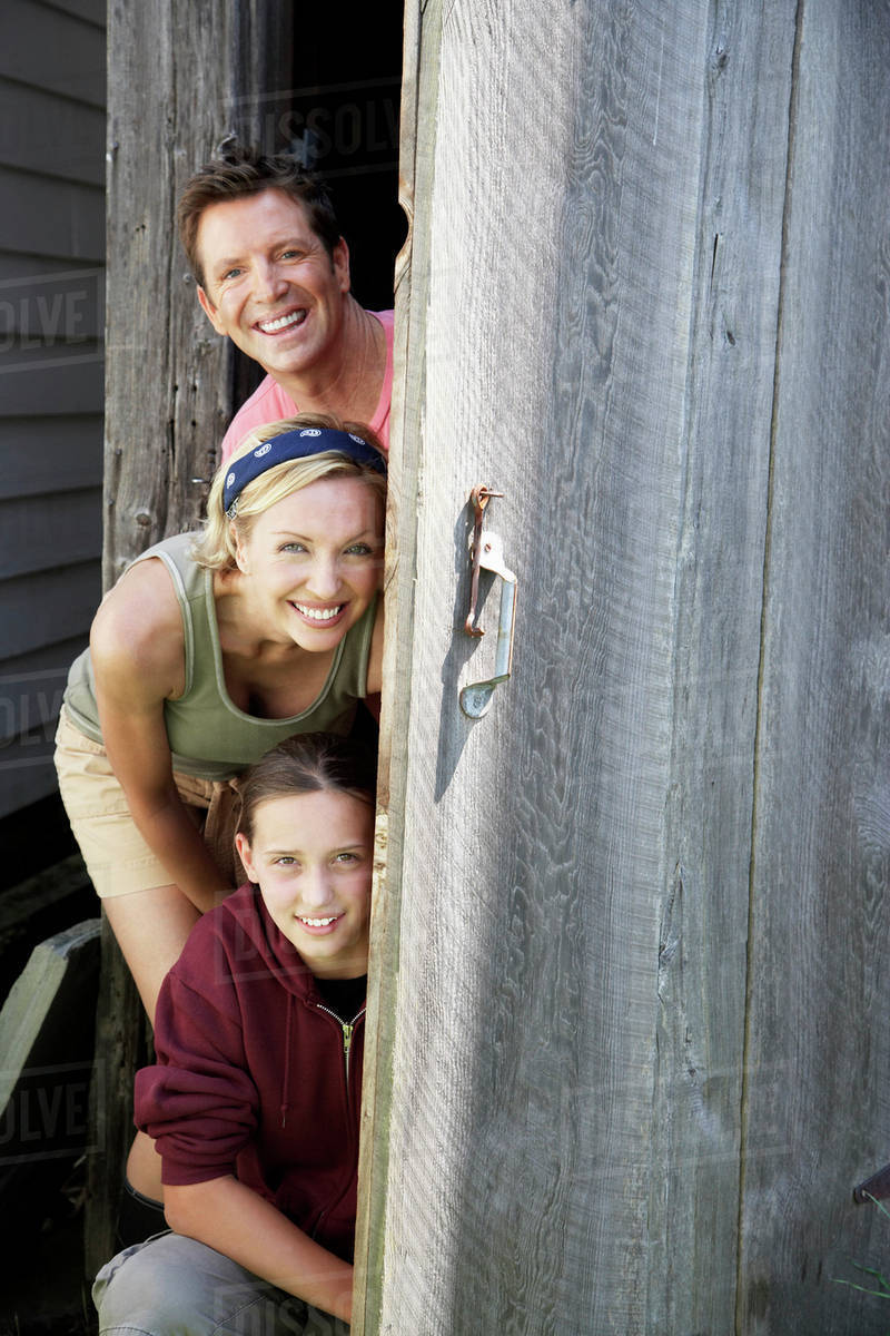 Family peeking out from behind door - Royalty-free Stock Photo | Dissolve