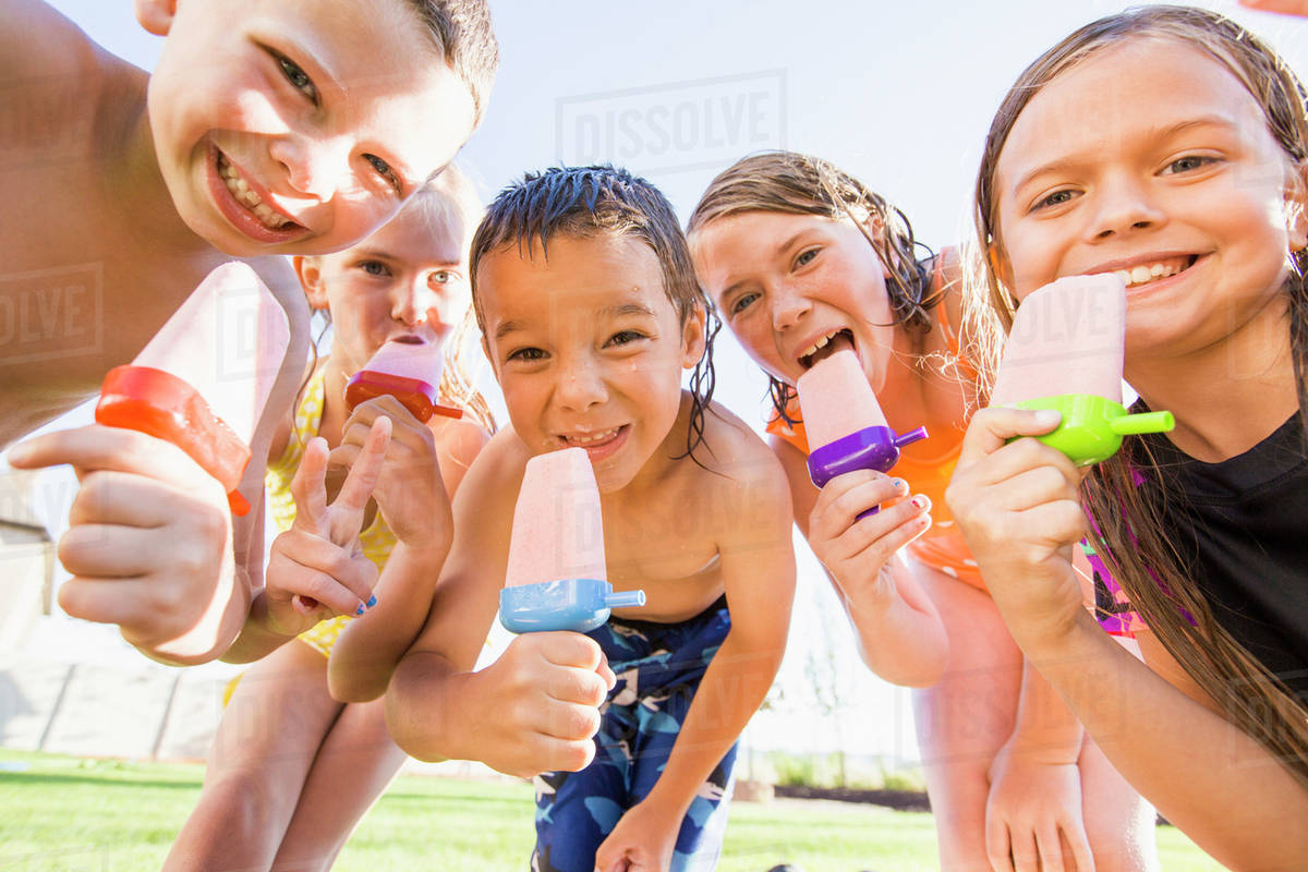 Caucasian children eating popsicles outdoors - Royalty-free Stock Photo ...