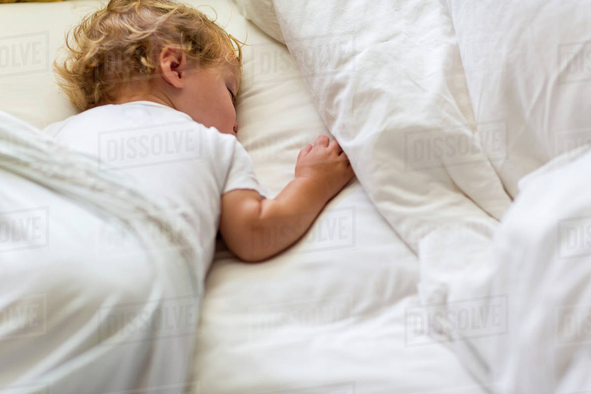 Caucasian toddler asleep in bed - Royalty-free Stock Photo | Dissolve