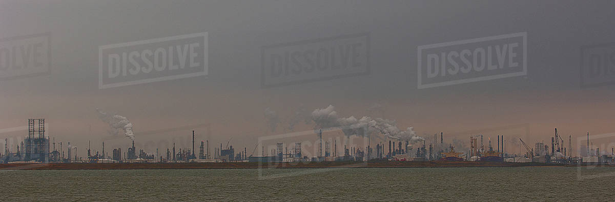 Smoke billowing from distant factory - Stock Photo - Dissolve