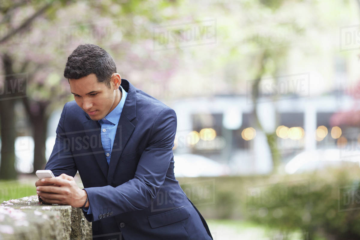 Man in suit using cell phone in urban park - Royalty-free Stock Photo ...
