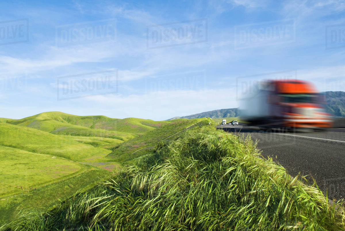 Truck driving on remote road in rolling landscape - Royalty-free Stock ...
