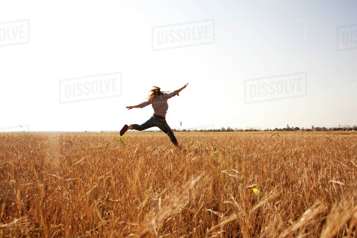 Caucasian woman jumping for joy in rural field - Royalty-free Stock ...