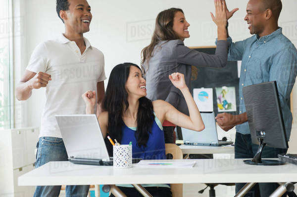 Business people cheering in office - Royalty-free Stock Photo | Dissolve