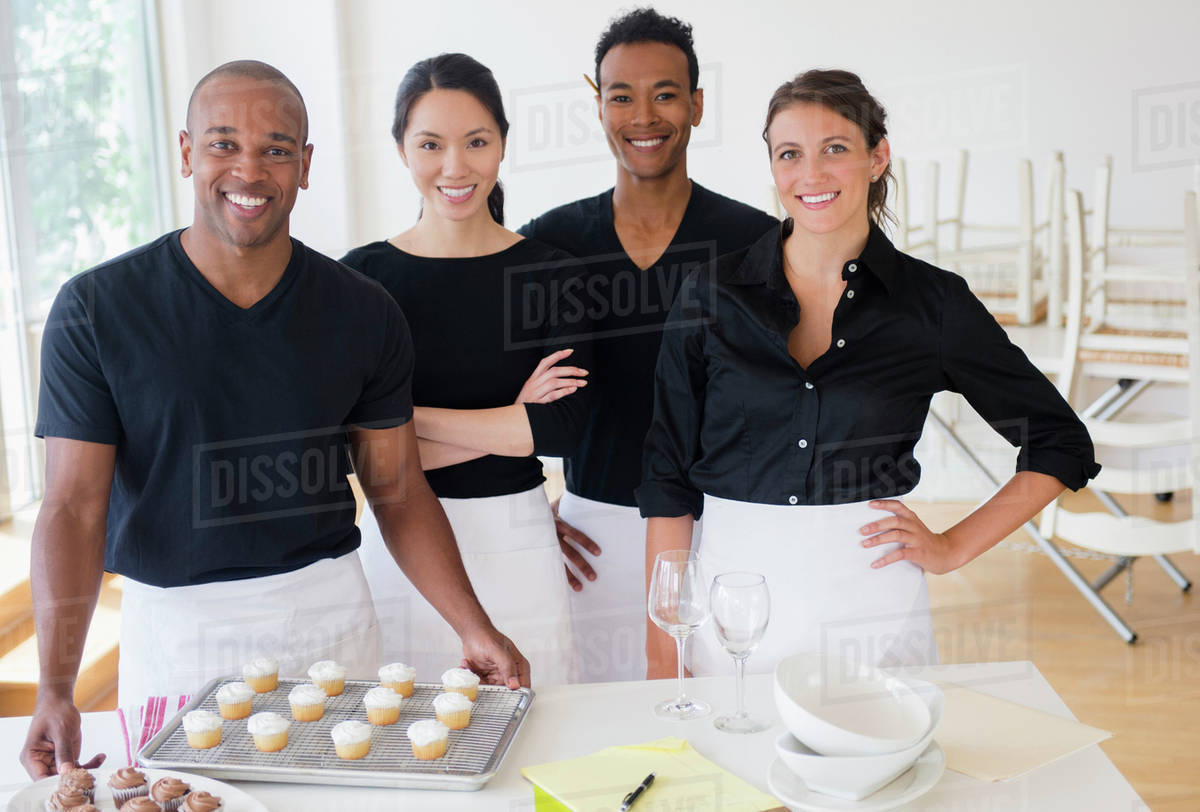 Caterers smiling with food in event space - Stock Photo - Dissolve