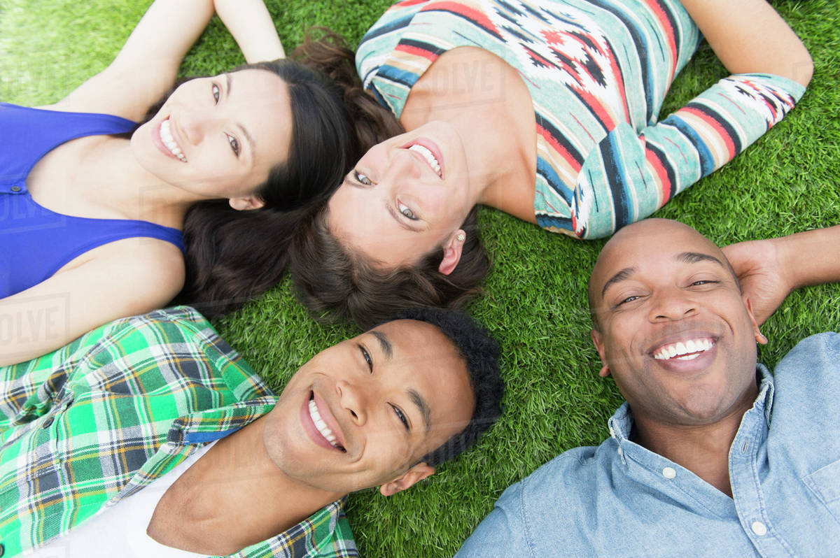 Friends laying in grass outdoors - Royalty-free Stock Photo | Dissolve