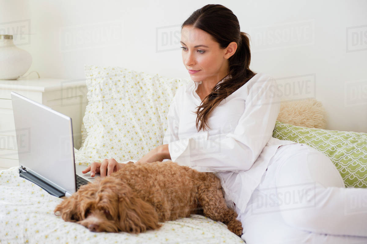 Caucasian woman using laptop with pet dog - Royalty-free Stock Photo ...