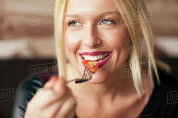 Woman eating food in cafe - Royalty-free Stock Photo | Dissolve