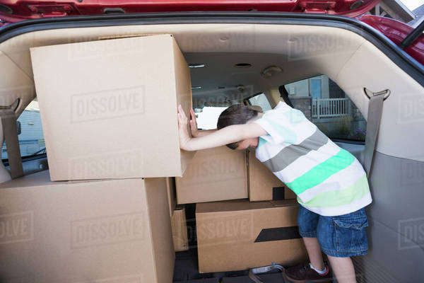 Caucasian boy packing cardboard boxes in car - Royalty-free Stock Photo ...