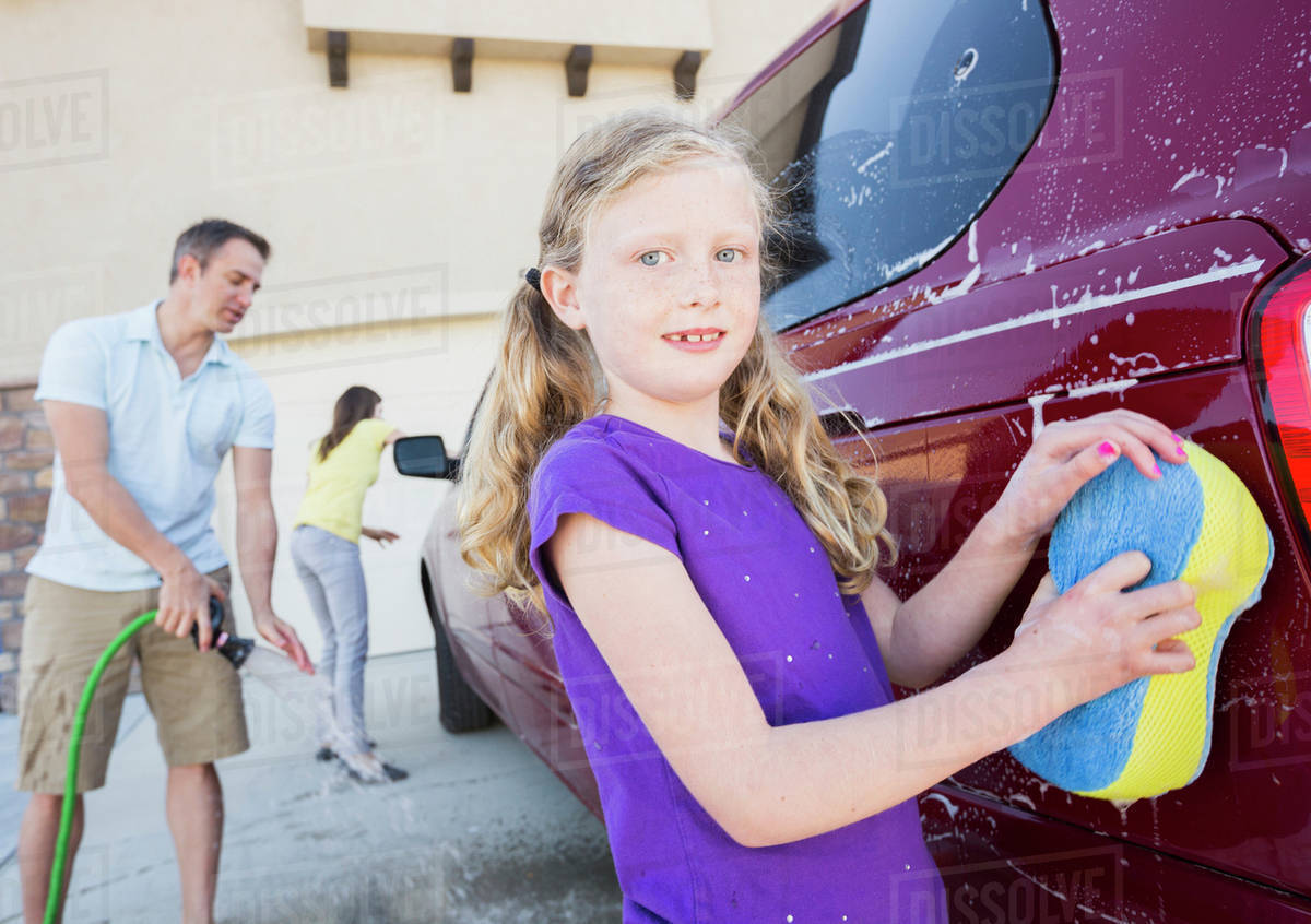 Caucasian father and children washing car in driveway - Royalty-free ...