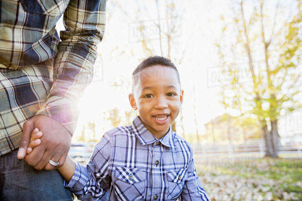 Black father and son walking in autumn leaves - Royalty-free Stock ...