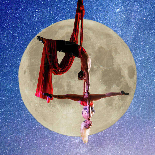 Caucasian acrobats performing with silk ropes by full moon - Royalty ...