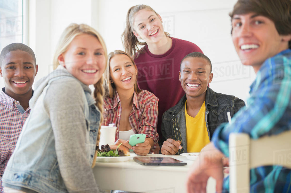 Teenagers smiling at table - Royalty-free Stock Photo | Dissolve