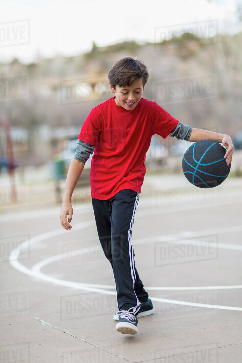 Caucasian boy playing basketball on court - Royalty-free Stock Photo ...