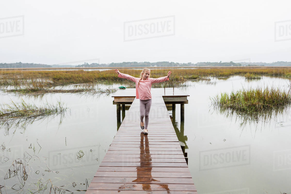 Caucasian girl standing on wooden dock over lake - Royalty-free Stock ...
