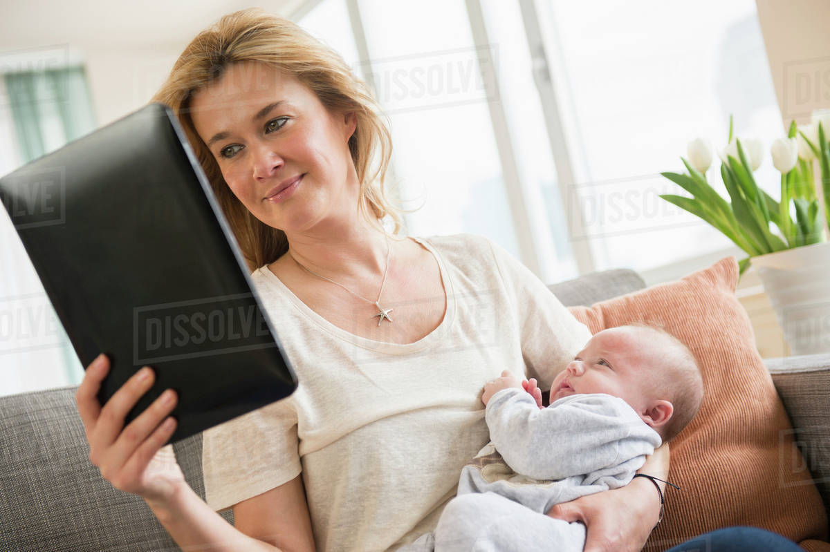 Caucasian mother with baby using tablet computer - Stock Photo - Dissolve