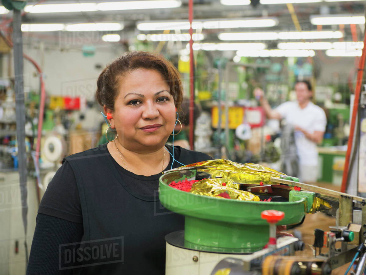 Hispanic worker operating machinery in textile factory - Royalty-free ...