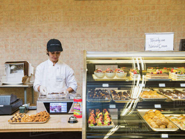 Middle Eastern woman working in bakery - Stock Photo - Dissolve