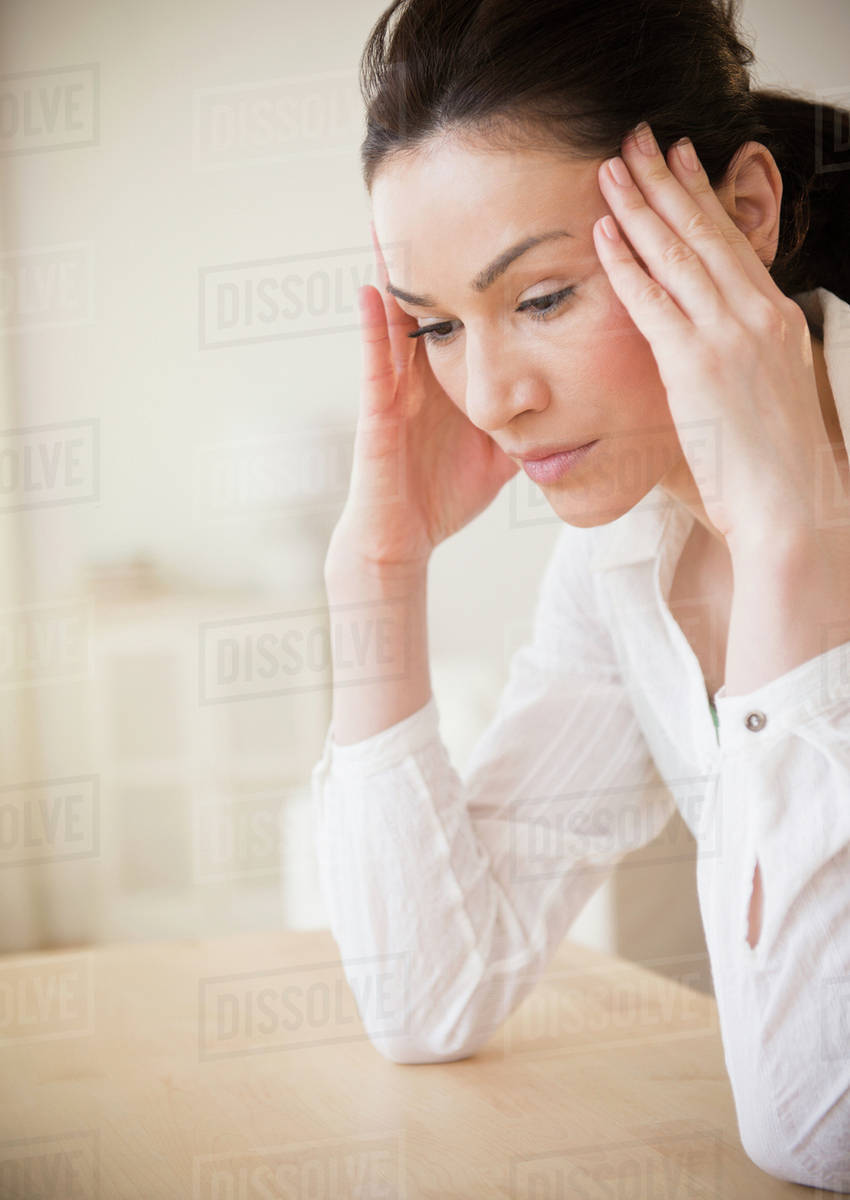 Caucasian woman rubbing her temples - Royalty-free Stock Photo | Dissolve