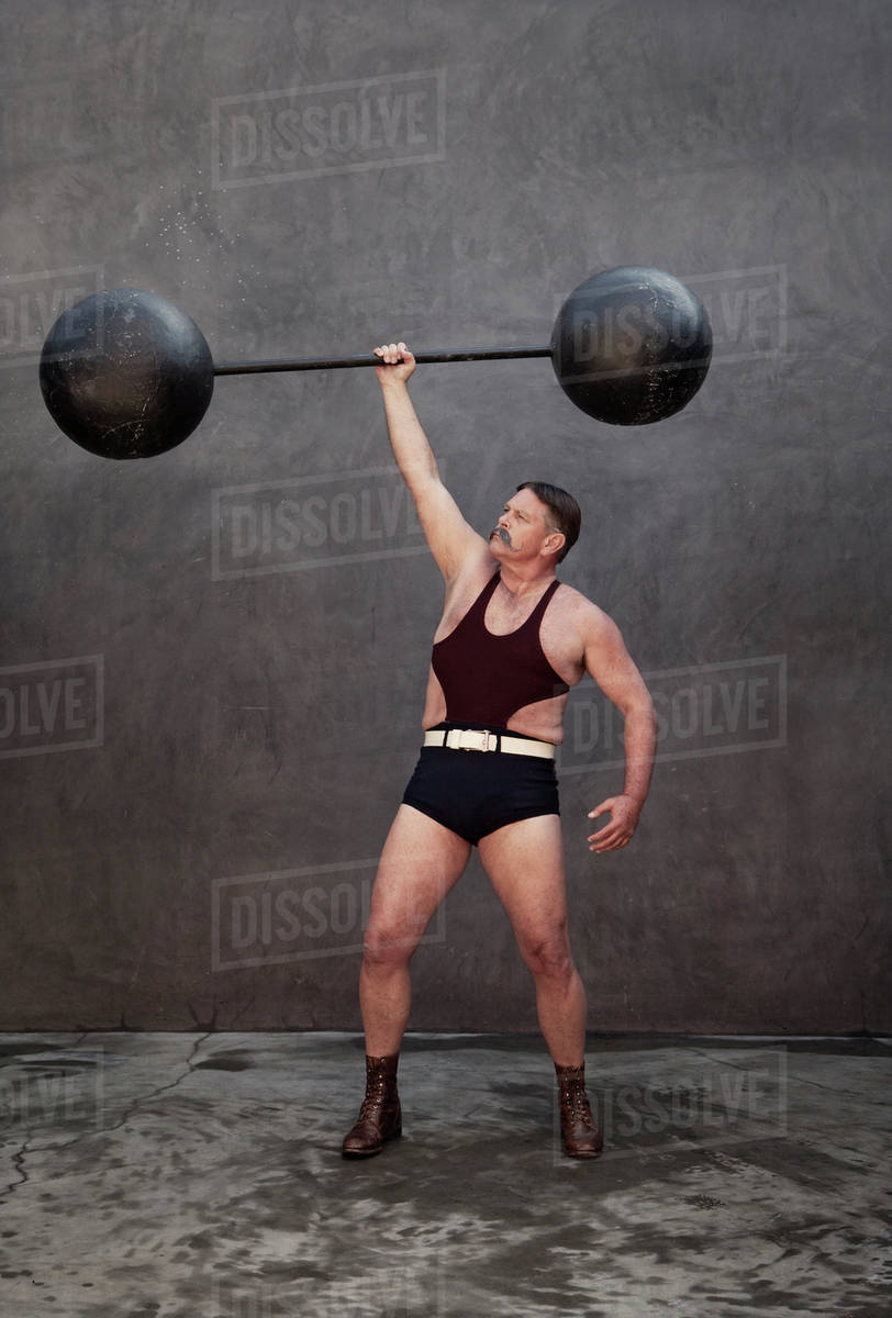 Caucasian weight lifter holding weights - Stock Photo - Dissolve