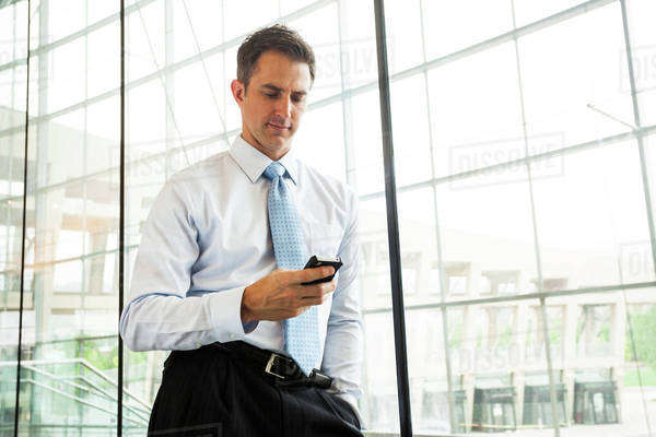 Caucasian businessman using cell phone - Stock Photo - Dissolve