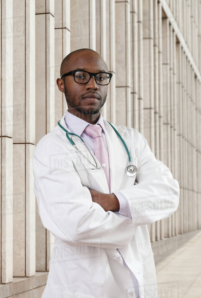 Black doctor standing on city street - Royalty-free Stock Photo | Dissolve