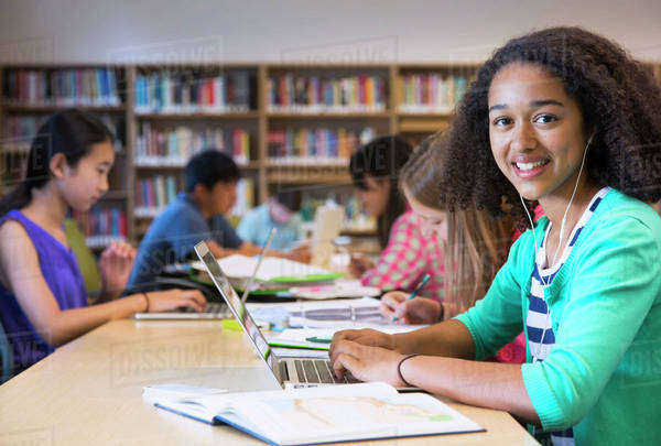 Student using laptop in library - Royalty-free Stock Photo | Dissolve
