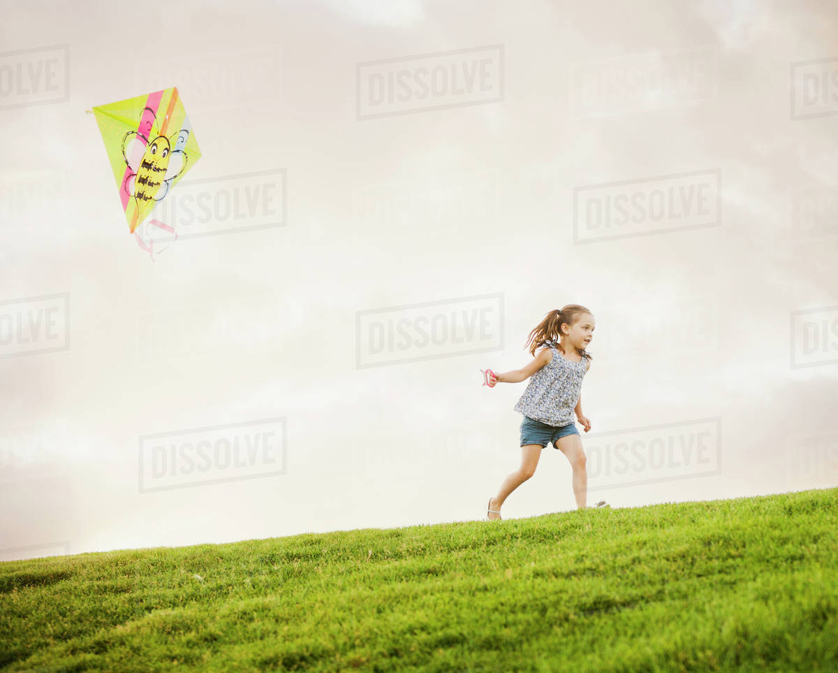 Caucasian girl flying kite - Royalty-free Stock Photo | Dissolve