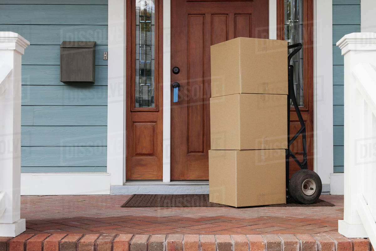Cardboard boxes on front porch of new house - Stock Photo - Dissolve