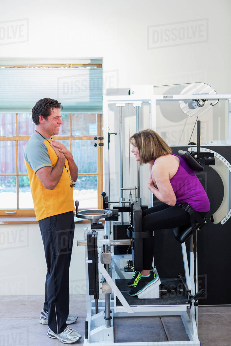 Caucasian woman working with personal trainer in gym - Royalty-free ...