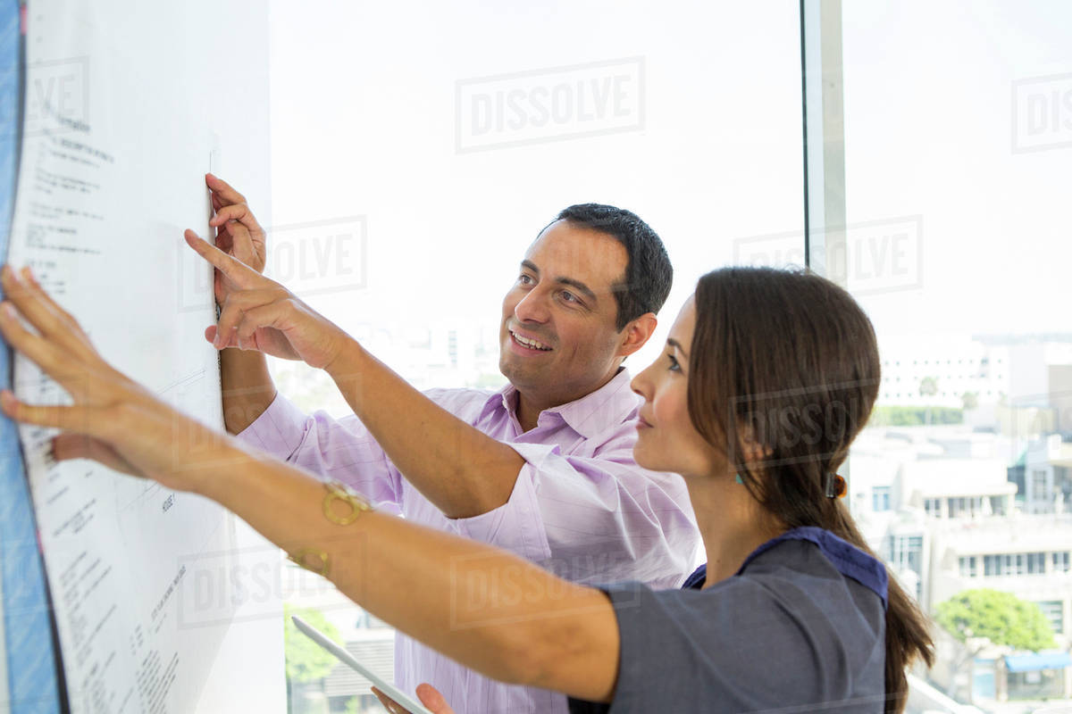 Business people examining blueprints in office - Royalty-free Stock ...