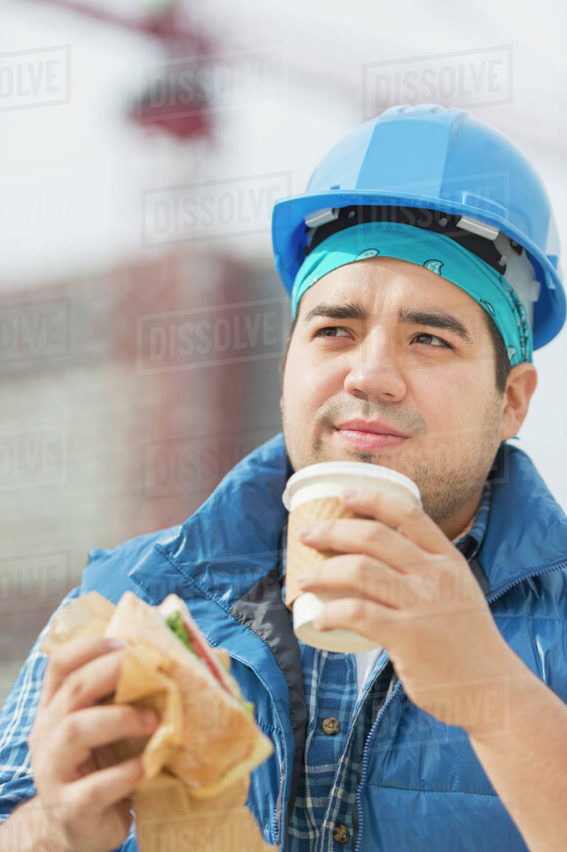 Mixed race worker eating lunch on construction site - Royalty-free ...