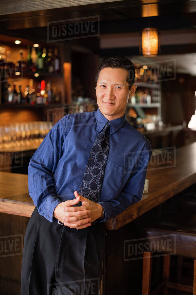 Korean owner leaning on bar - Royalty-free Stock Photo | Dissolve