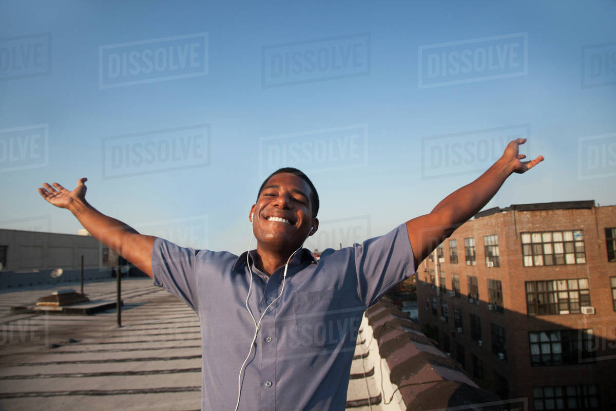 Black man with arms outstretched on rooftop - Royalty-free Stock Photo ...